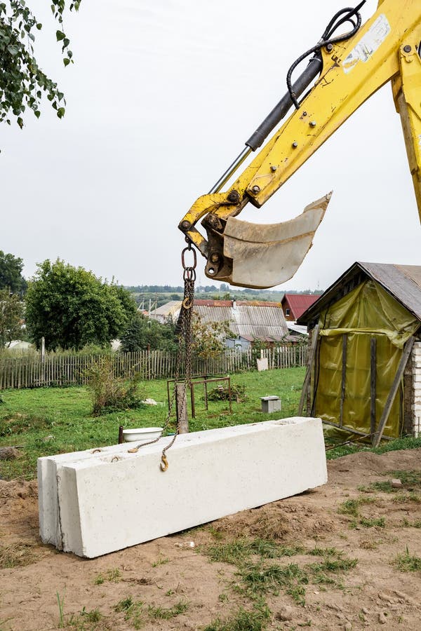 Wheel Loader. Excavator Install the Foundation Blocks into a Trench ...