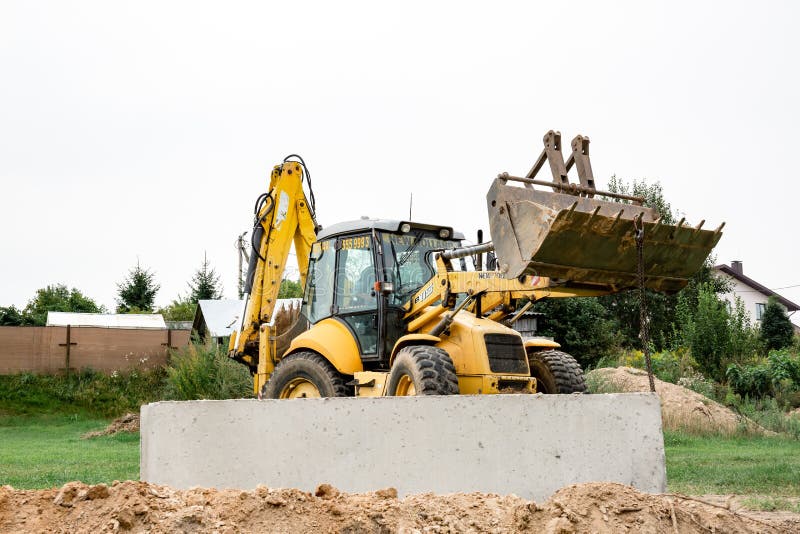 Wheel Loader. Excavator Install the Foundation Blocks into a Trench ...