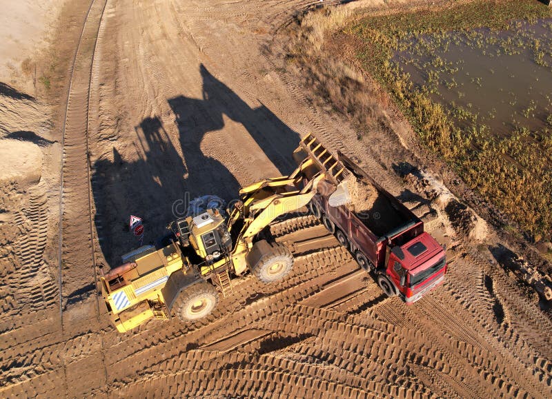 Wheel Loader Load the Sand into Dump Truck in Open Pit. Developing the ...