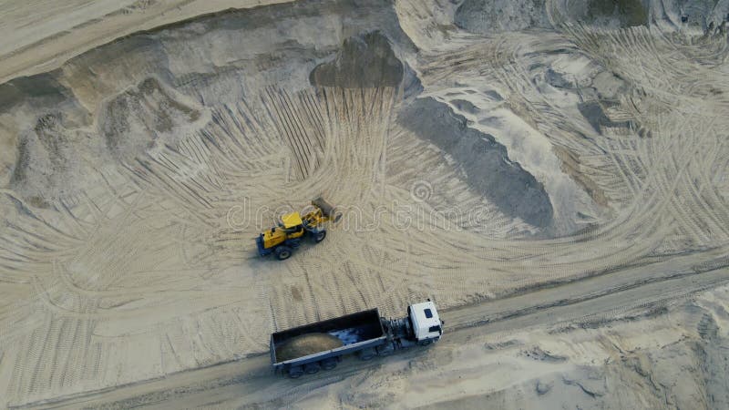 Wheel Loader Loading Sand into Dump Truck in Open Pit Mine. Arial View ...