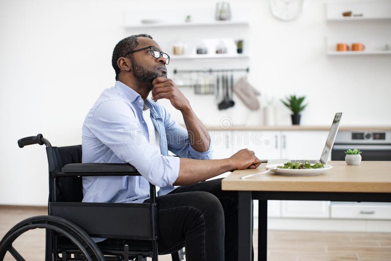 Wheelchair User Typing on Computer in Kitchen Interior Stock Photo ...