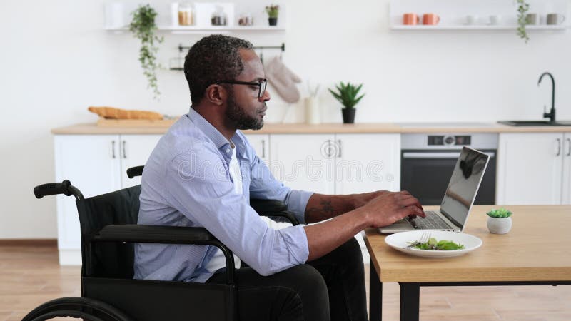 Wheelchair User Typing on Computer in Kitchen Interior Stock Video ...