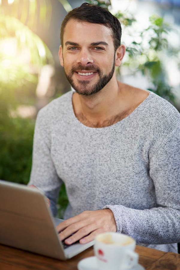 Where the Coffee and Wifi Flows. a Handsome Young Man Using a Laptop at ...