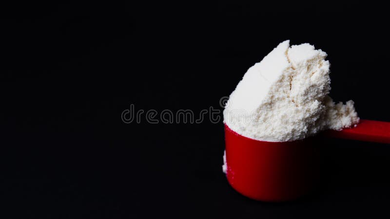 Whey Protein Powder in a Red Measuring Spoon on a Black Background ...