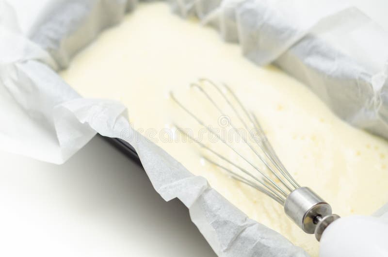 A Whisk is Sitting in the Dough in a Loaf Tin with a Sheet of Parchment ...