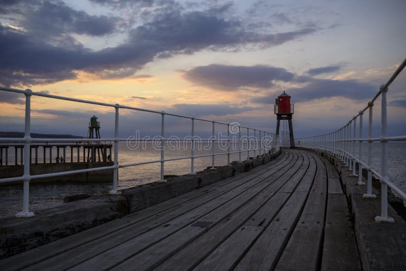 Whitby East Pier at sunset stock photo. Image of water - 254860948