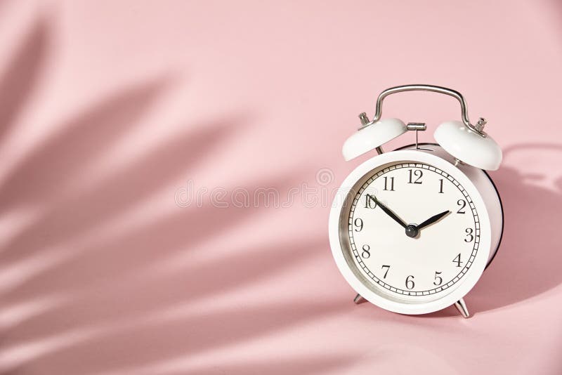 White Alarm Clock and Leaves Shadows on Pastel Pink Background Stock ...