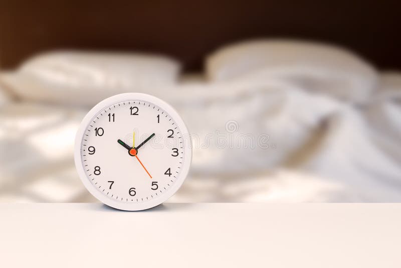 White Alarm Clock on White Desk on Blurred White Messy Bedding Sheet ...