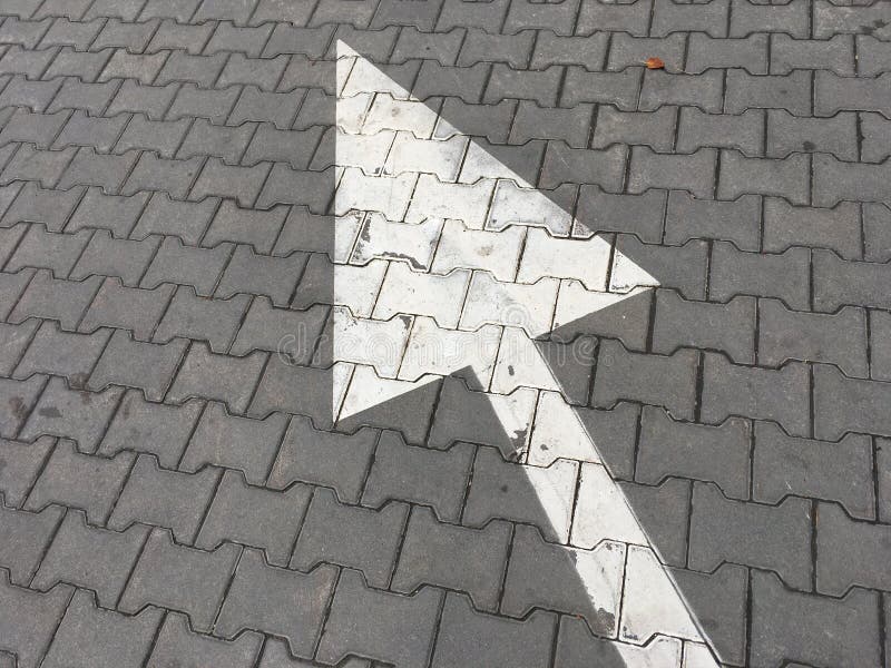 White arrow on road tile stock image. Image of rock - 193119651