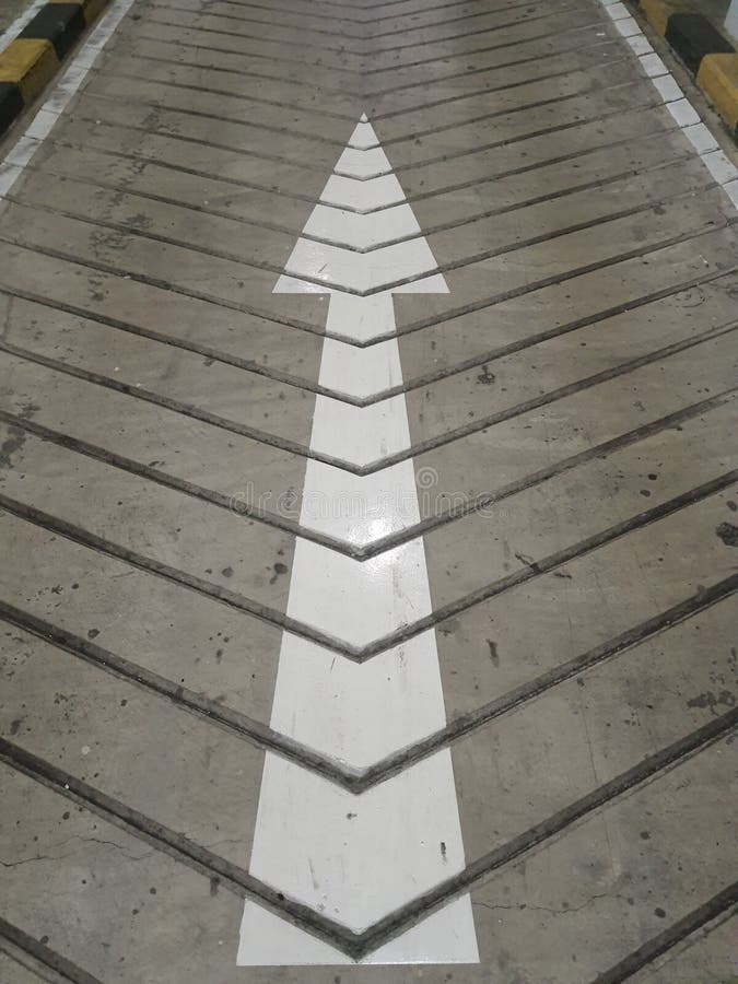 White Arrows Sign Painted on Empty Parking Lot Stock Photo - Image of ...