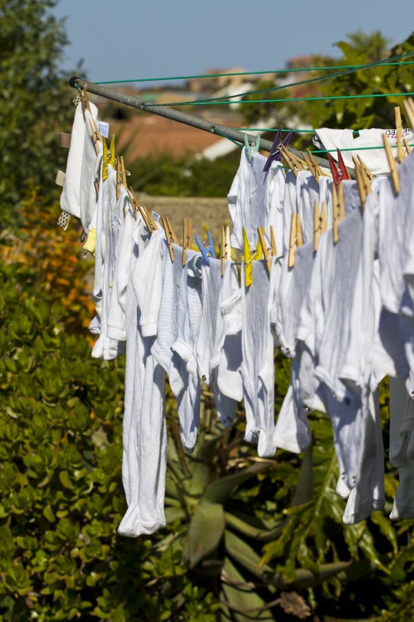 White Baby Clothes on a Washing Line Stock Photo - Image of plants ...