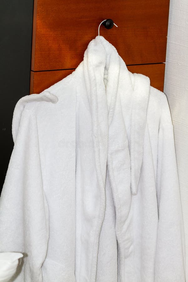 White Bath Robe Hanging on a Wooden Drawer Stock Image - Image of robe ...