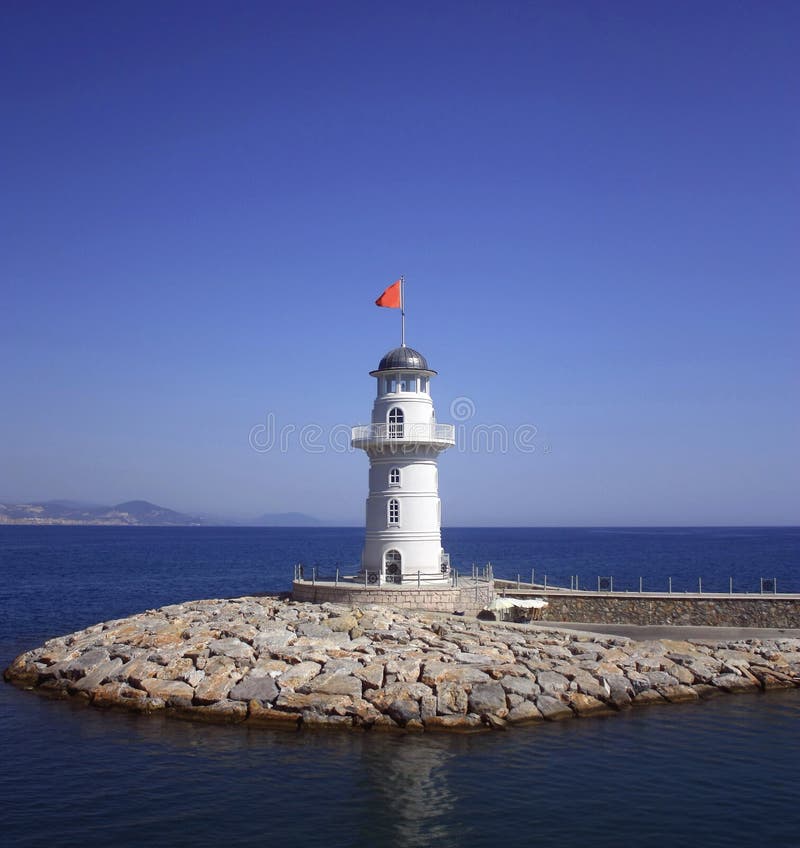 White Beacon Near Coast with a Red Flag Stock Image - Image of ...