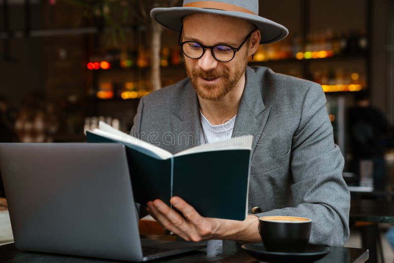 White Bearded Man Reading Book while Drinking Coffee in Cafe Outdoors ...