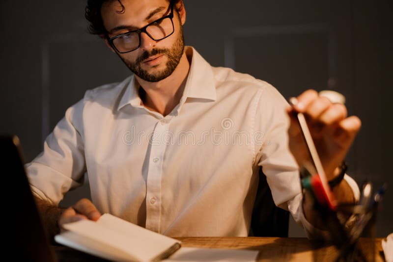 White Man Writing Down Notes in Planner while Working at Office Stock ...