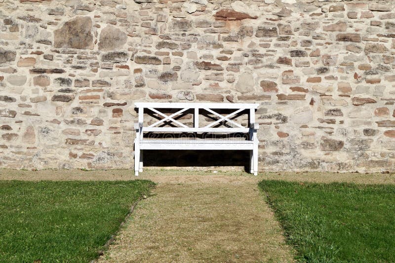 White Bench in a Park in Front of a Medieval Wall Stock Photo - Image ...
