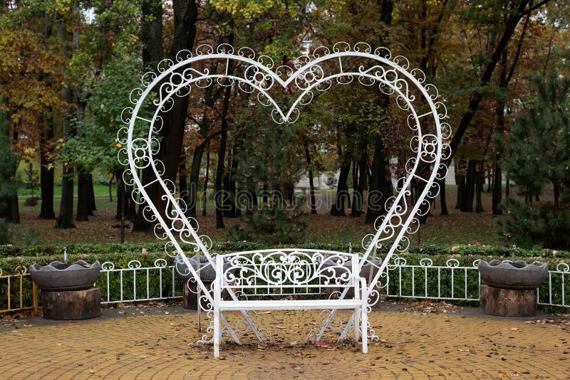 White Bench in the Park in the Shape of a Heart on the Background of an ...