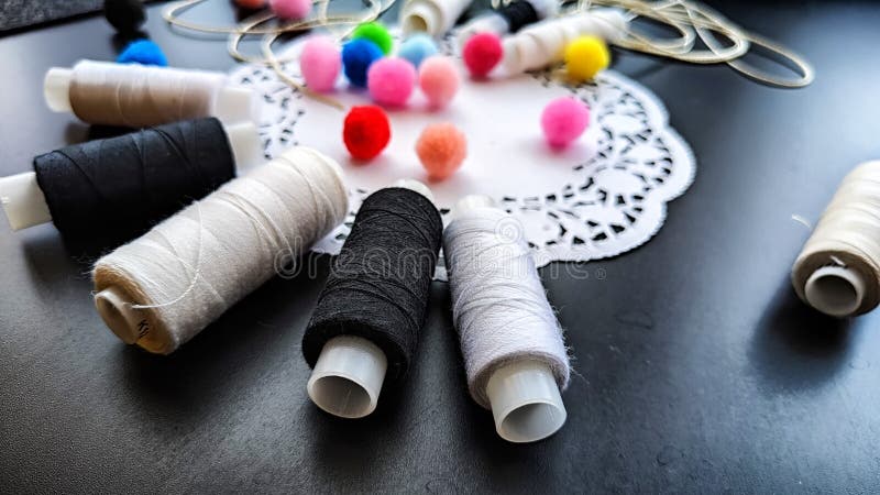 White and Black Spools of Thread with Decorative Napkin and Colored ...