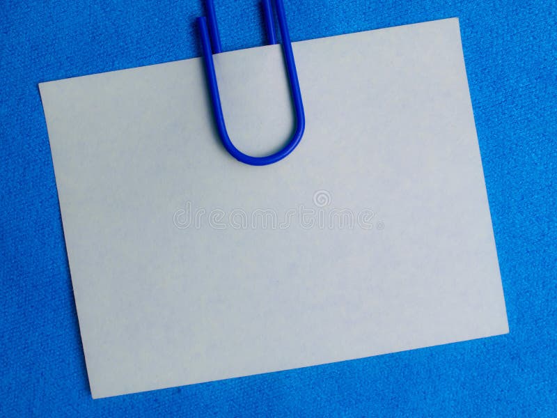 White Blank Note Pinned To a Blue Notice Board with a Paper Clip Stock ...