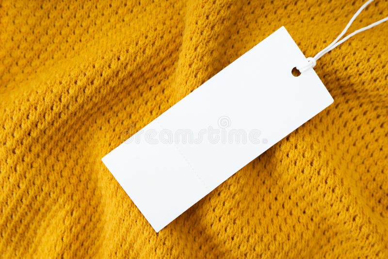 White Blank Rectangular Clothing Tag on Yellow Knitted Fabric ...