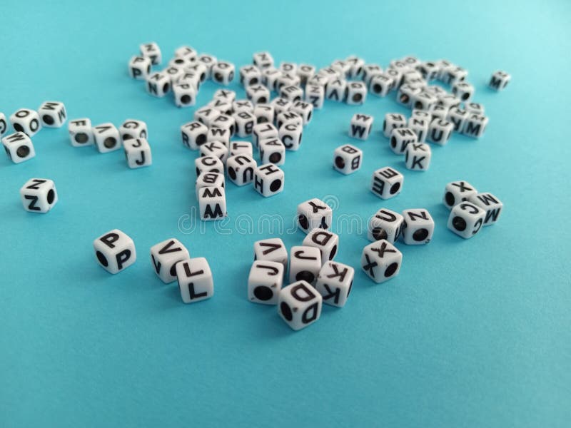 White Blocks with Alphabet Letters on Them Scattered on a Blue ...