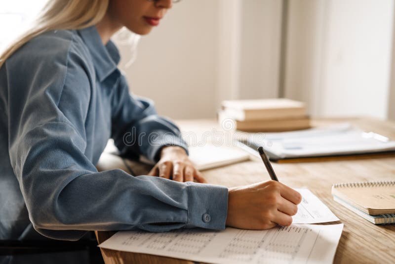 White Woman Working with Papers while Sitting at Table in Home Stock ...