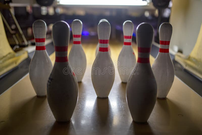 White Bowling Pins and an Orange Ball on a Bowling Alley. Reflection ...