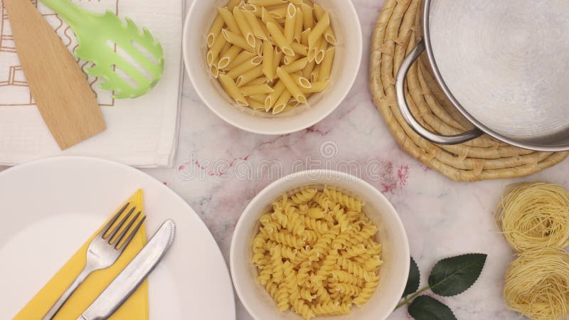 White Bowls with Pasta Moving on Table with Kitchen Utensils - Stop ...