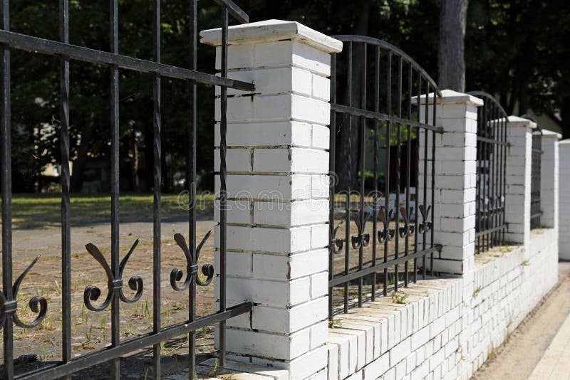 White Brick Fence Posts with Metal Fence Panels between the Posts Stock ...