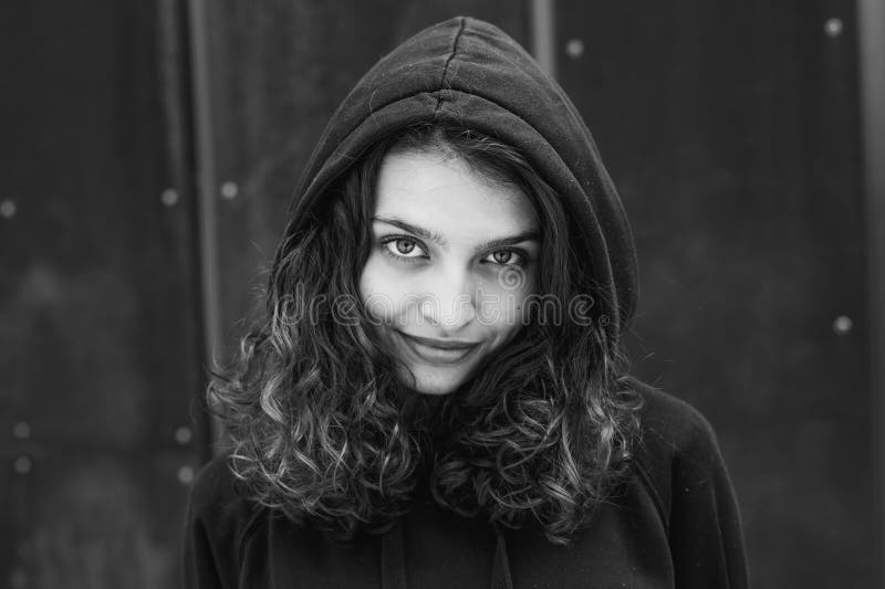 White Brunette Teenage Girl With Curly Hair Poses On The Street In The