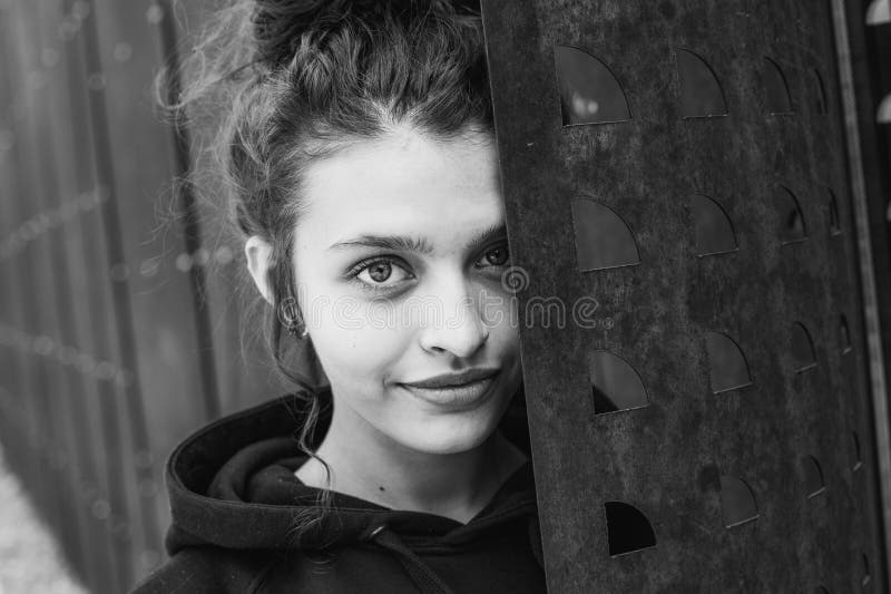 White Brunette Teenage Girl With Curly Hair Poses On The Street In The