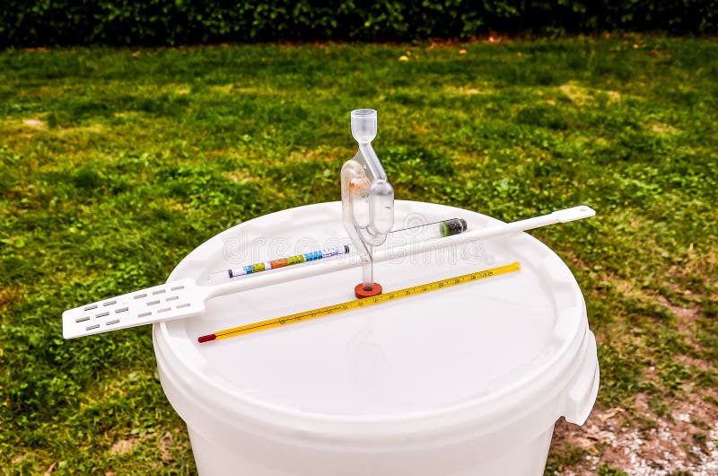 A White Bucket with a Ruler and a Thermometer on Top of it Stock Image ...