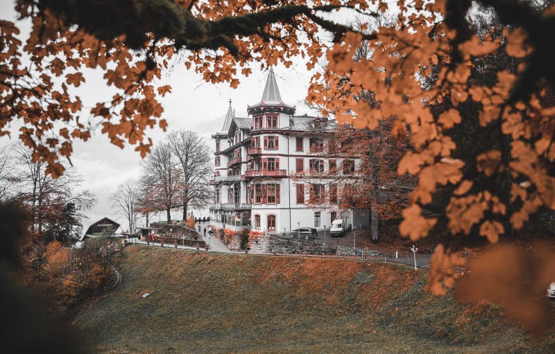 White Building with a Pointed Spire and an Array of Vibrant Red Foliage ...