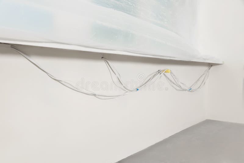 White Cables on Plastered Wall Indoors. Installation of Electrical ...