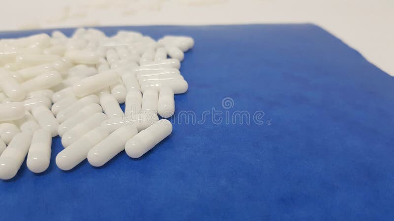 White Capsules on Blue Background Stock Image - Image of help, dosage ...