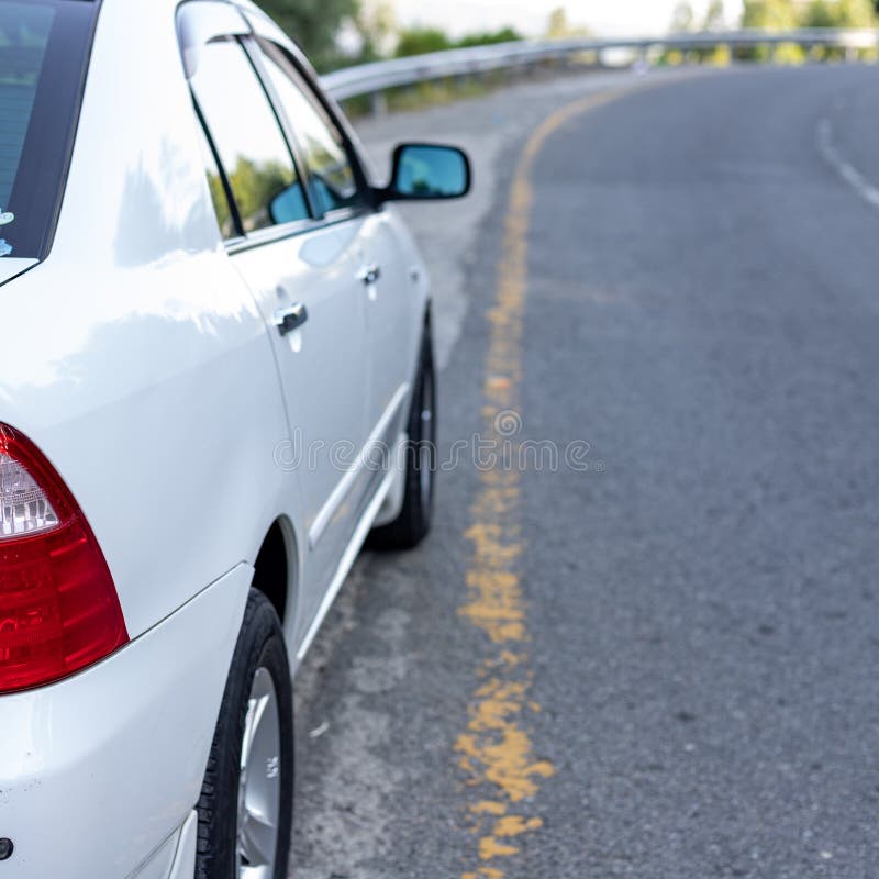 White Car with Tail Lights Parked on the Side of an Asphalt Road in the ...