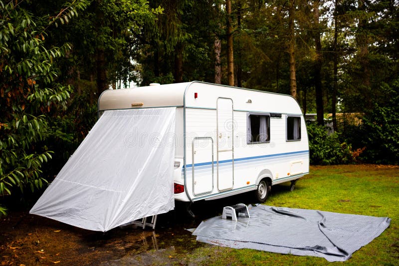 White Caravan with Awning in Forested Campsite Setting Stock Image ...