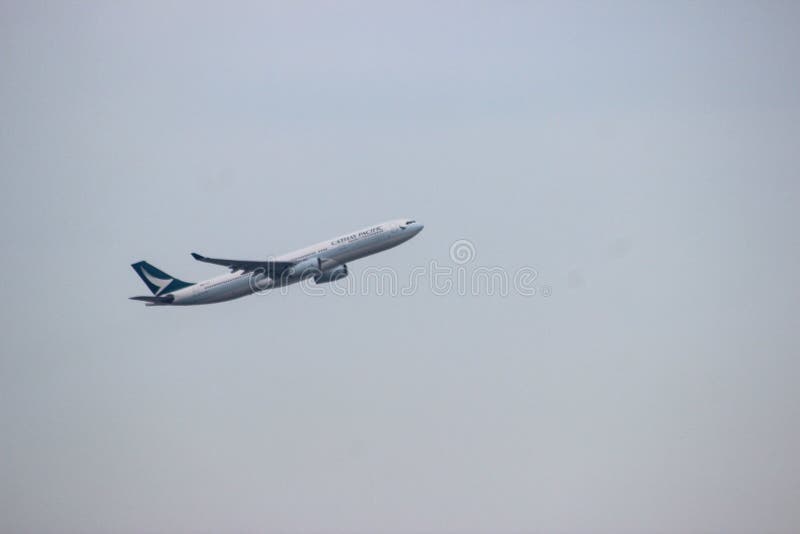 White Cathay Pacific Aircraft Flying in the Clear White Sky Editorial ...