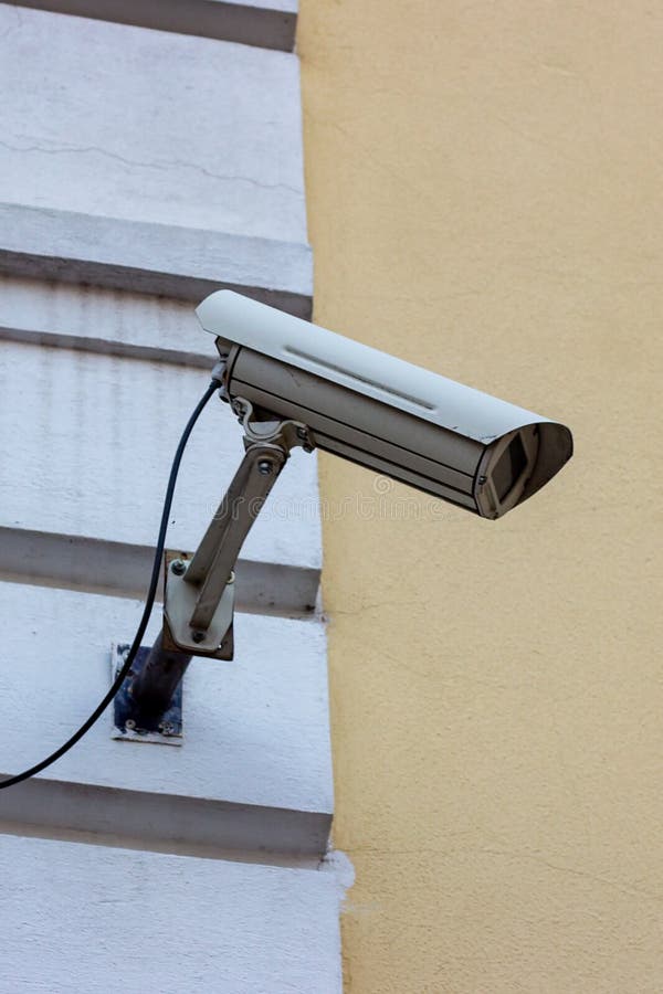 White CCTV Security Camera on the Wall in the City Street. Stock Photo ...