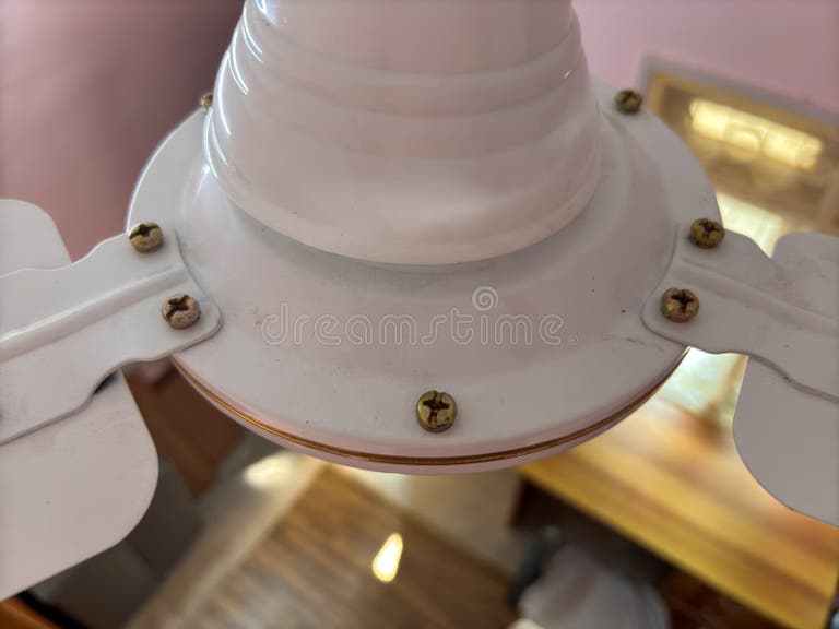 A White Ceiling Fan with a White Base and a Black Handle Stock Photo ...