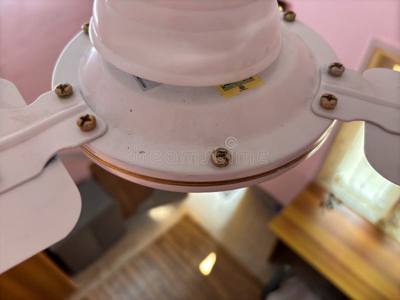 A White Ceiling Fan with a White Base and a Black Handle Stock Photo ...