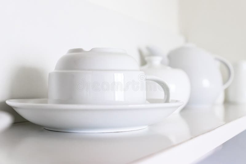 White Ceramic Coffee Cups and Saucers Standing in a Row on a Shelf in ...