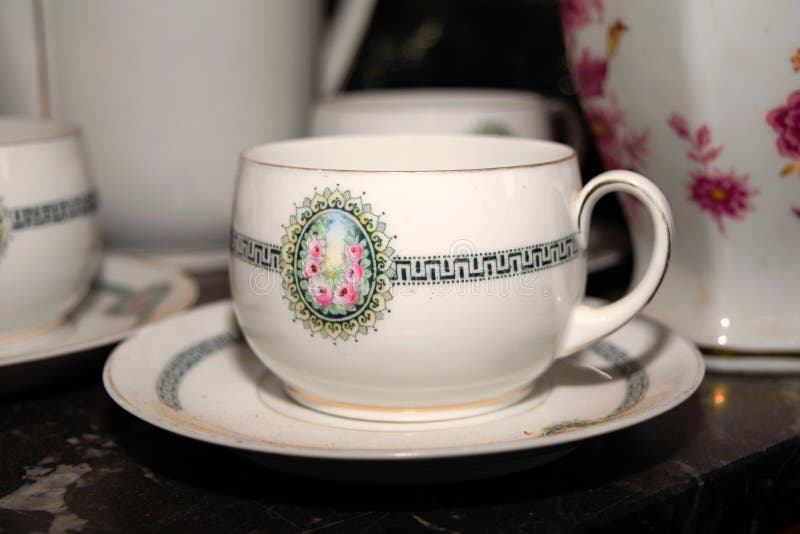 White Ceramic Cup with Decorations. the Rest of the Tableware in the ...