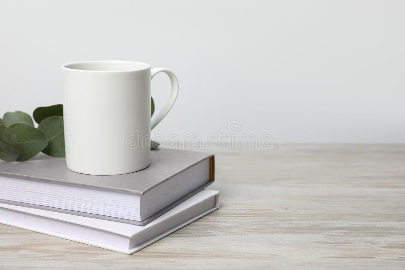 White Ceramic Mug, Stack of Books and Eucalyptus Branch on White Wooden ...