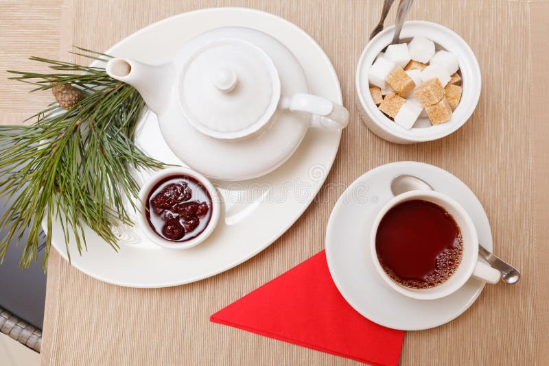 A White Ceramic Teapot and a Cup of Tea, Jam and Sugar Pieces. Top View ...