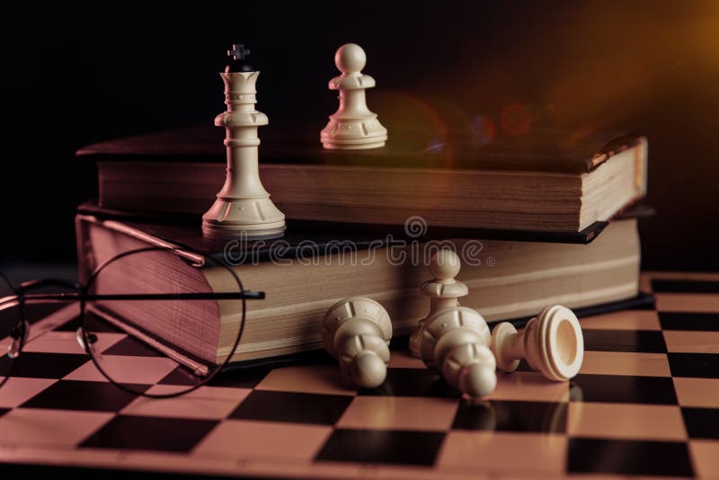 White Chess Pieces on the Chessboard with Books and Glasses Stock Photo ...