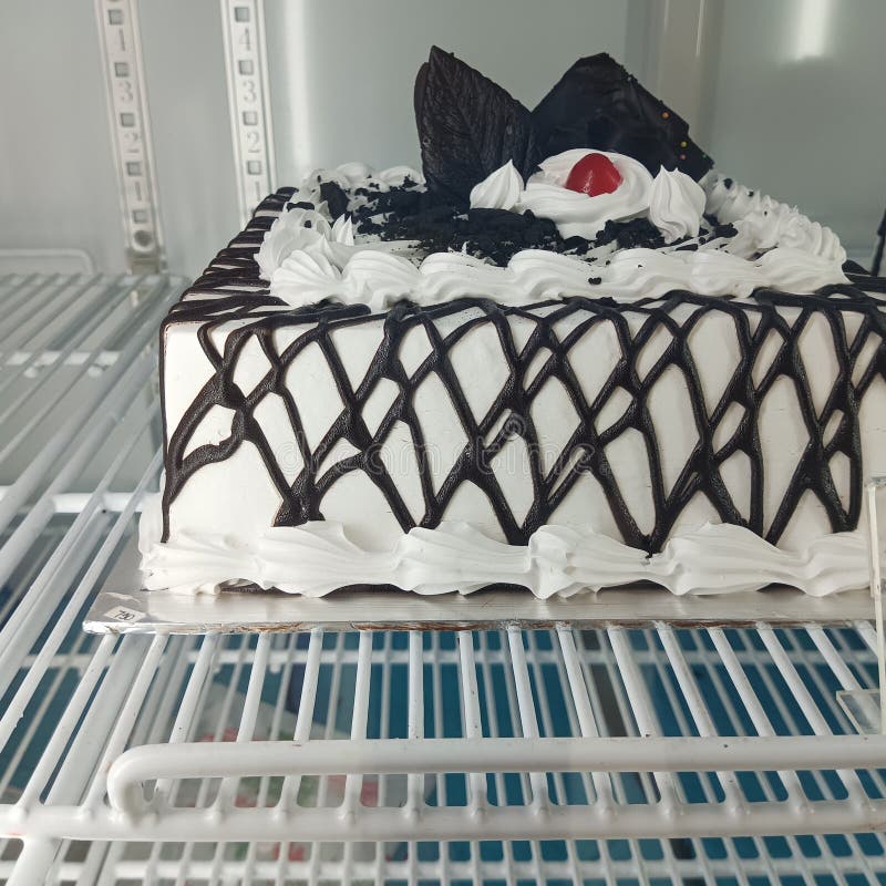 A White Chocolate Motif Birthday Cake Placed in the Refrigerator Stock ...