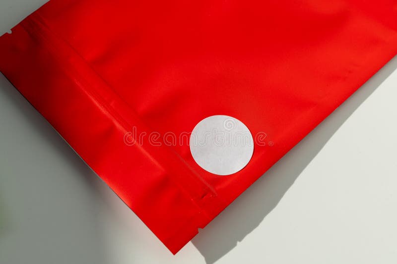 White Circular Sticker on Red Poly Mailer Envelope with Natural Shadow ...
