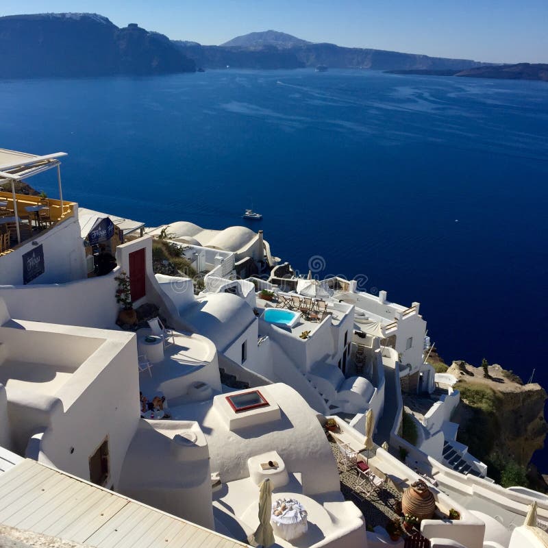 White Cliffside Buildings in Greece Overlook the Blue Mediterranean ...