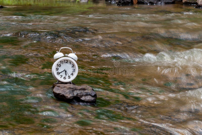 White Clock Laying on a Rock in a Waterfall. Stock Image - Image of ...